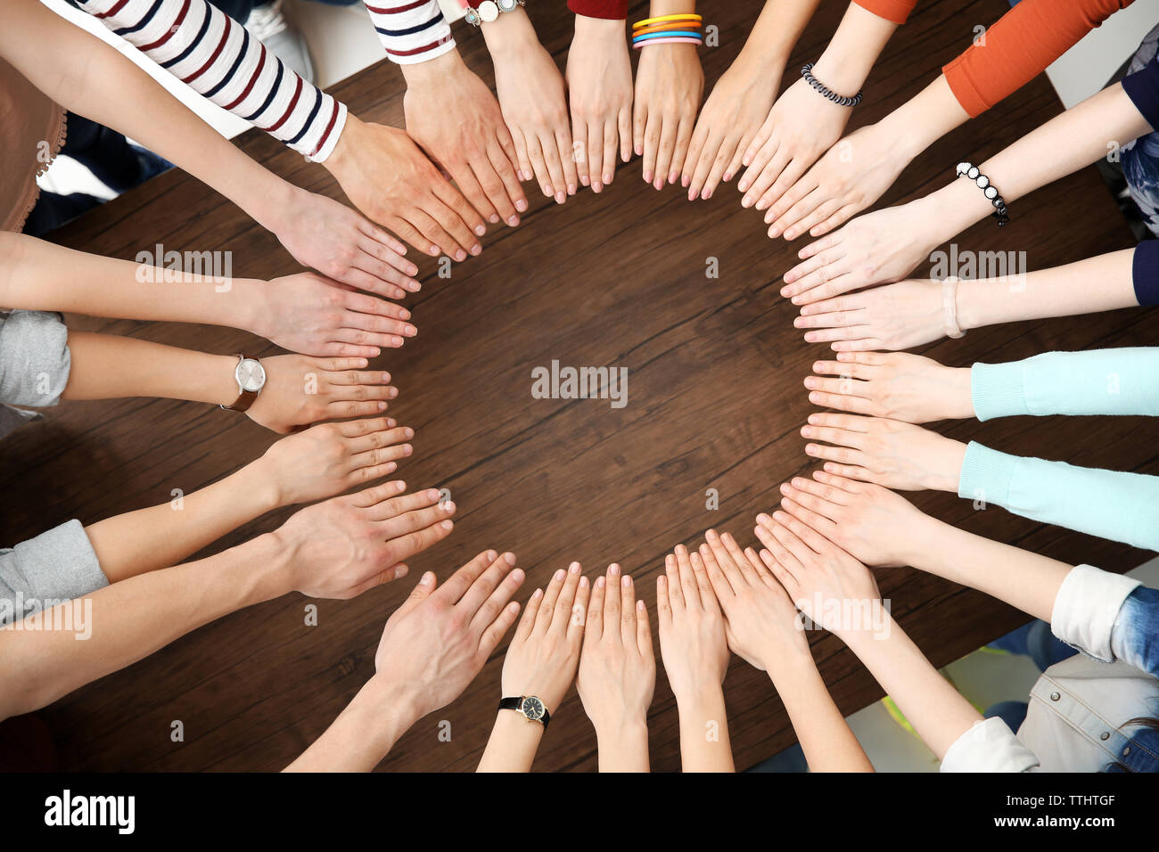 Group of people hands together on wooden background Stock Photo - Alamy