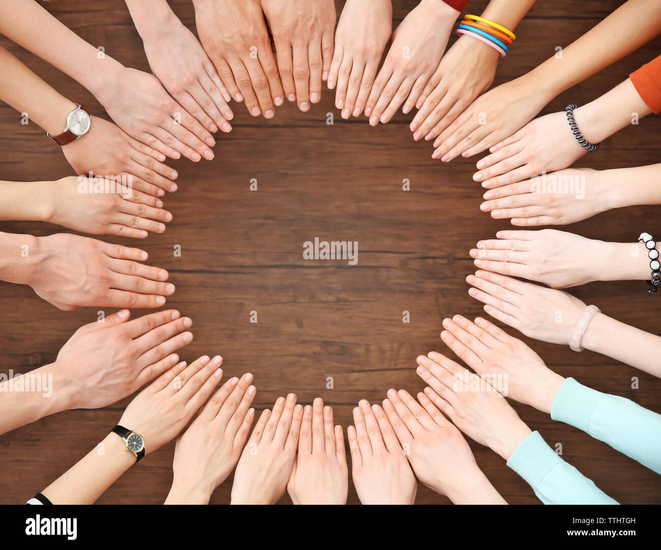 Group of people hands together on wooden background Stock Photo - Alamy