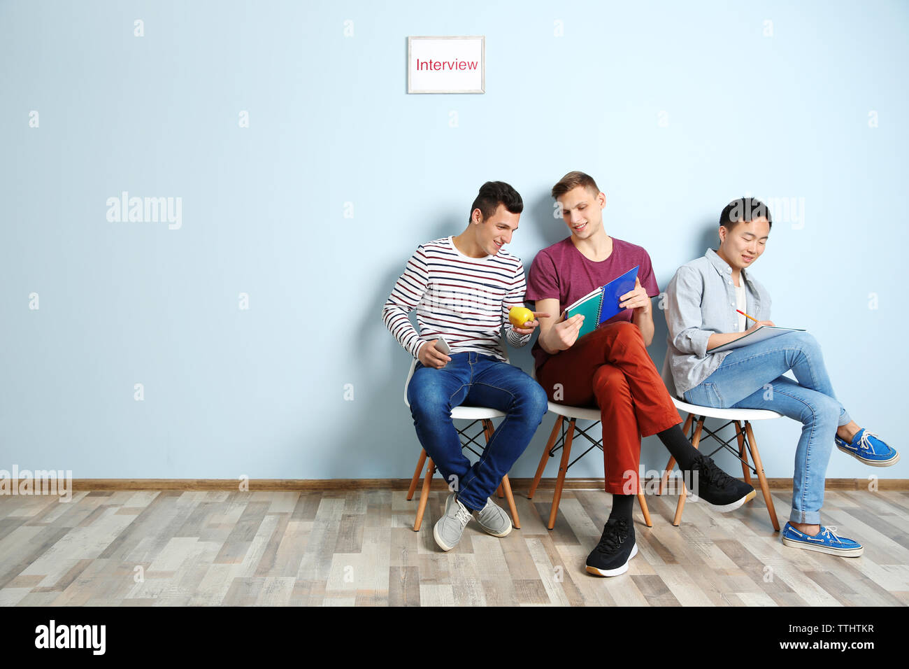 Three men waiting for interview indoors Stock Photo - Alamy