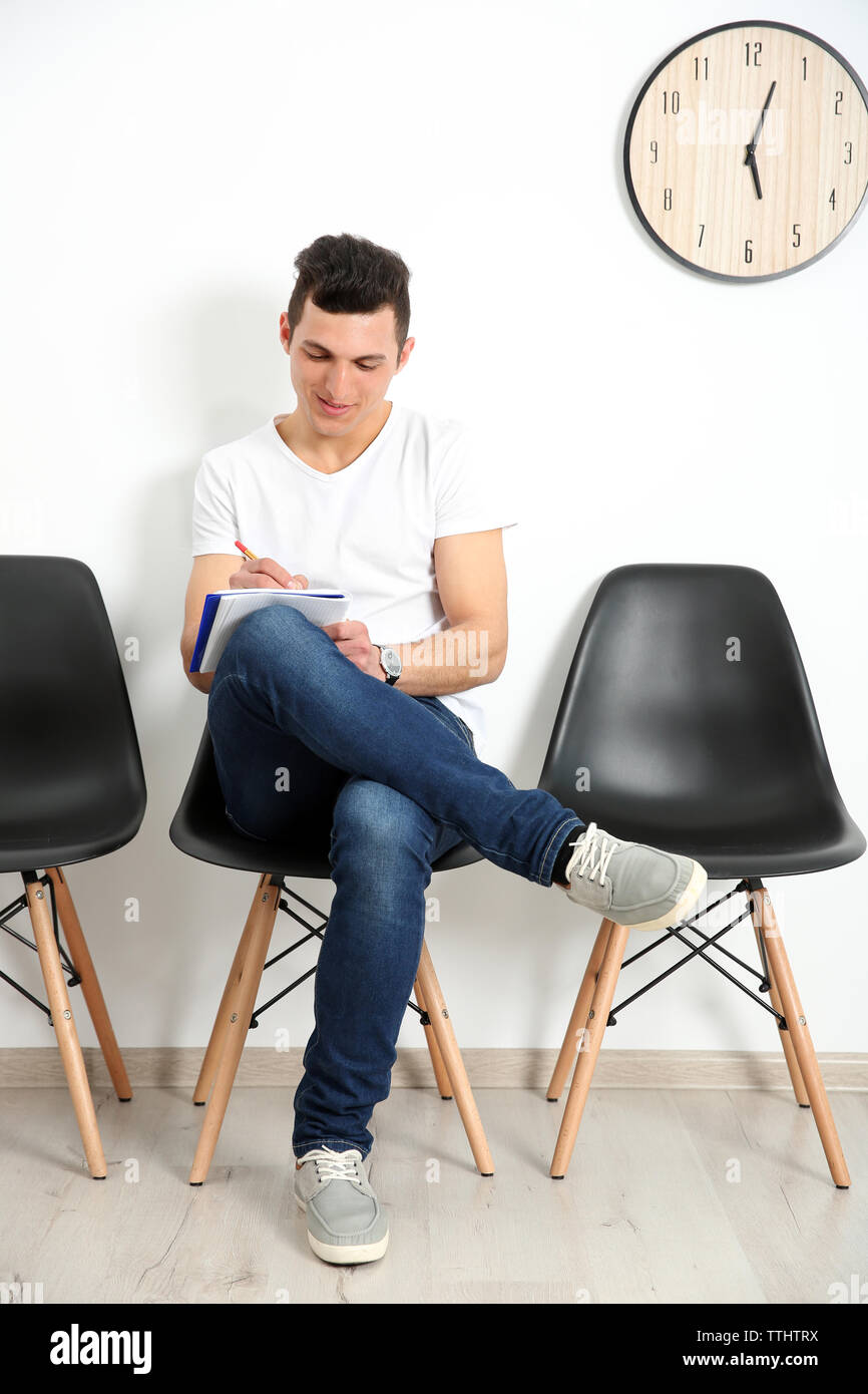 Young man waiting for interview indoors Stock Photo - Alamy