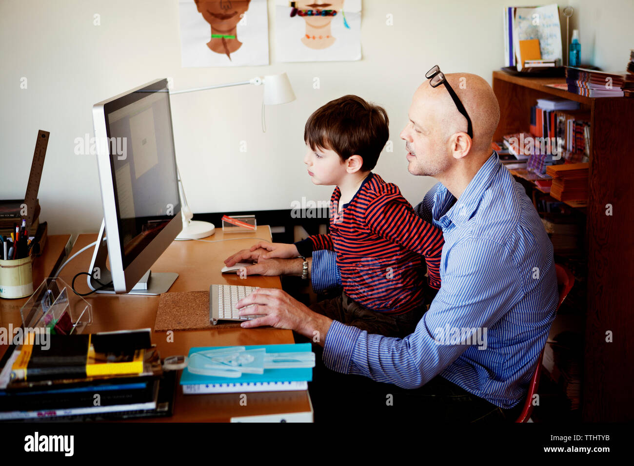 Father and son using desktop computer while sitting at table Stock ...