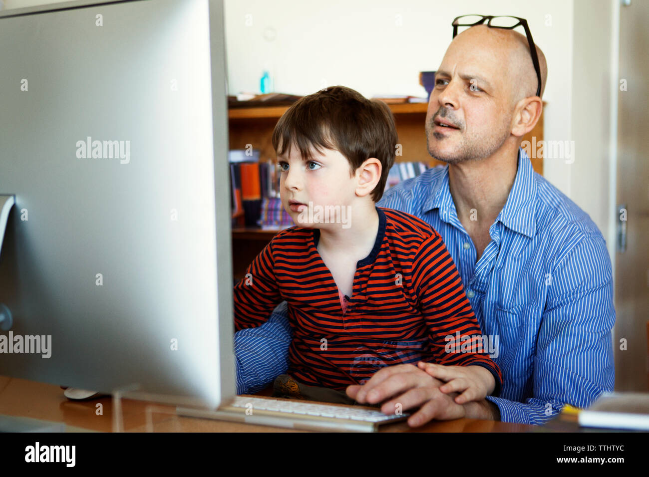Father and son using desktop computer at home Stock Photo - Alamy