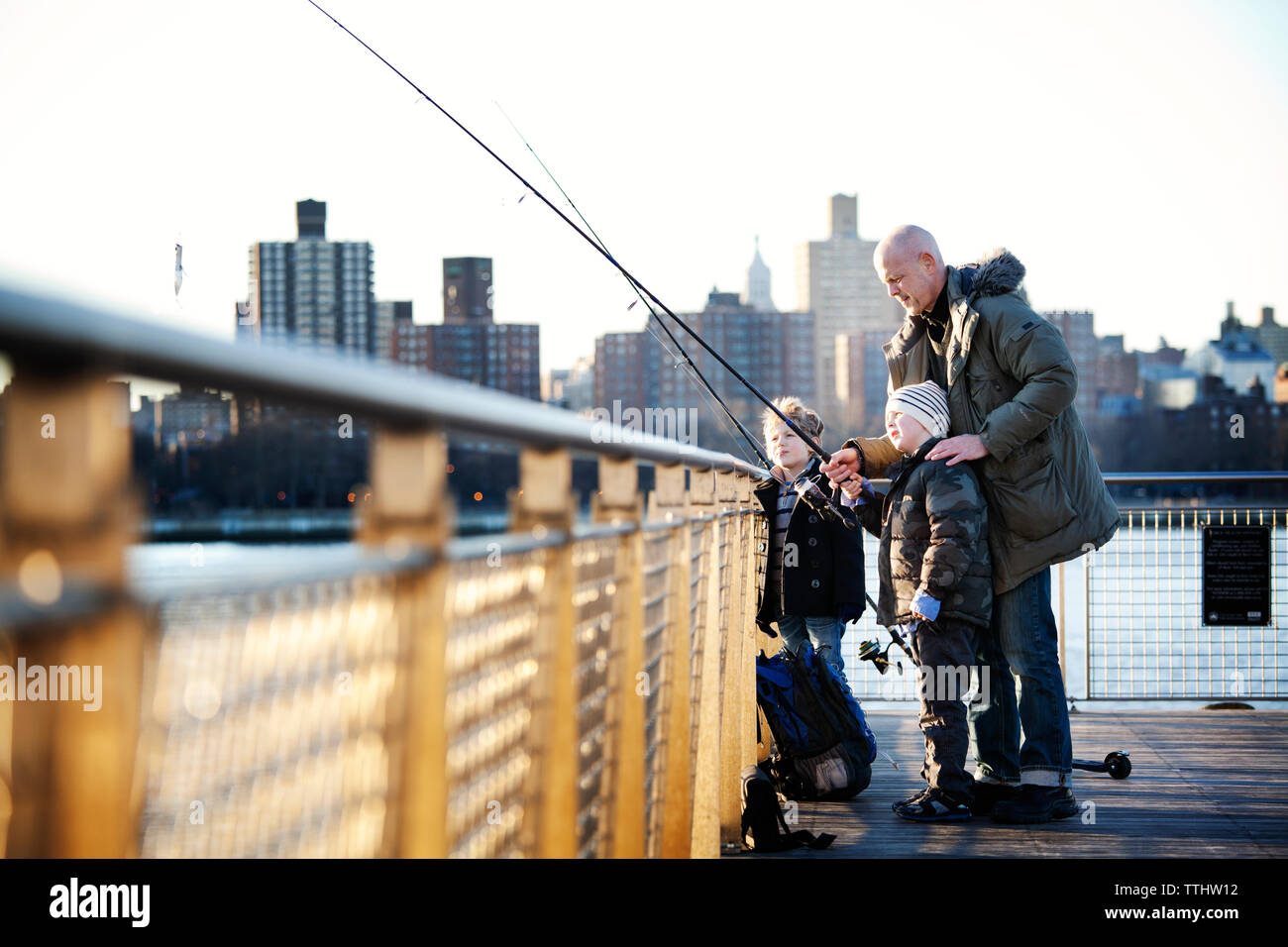 Father teaching fishing to kids against clear sky Stock Photo - Alamy