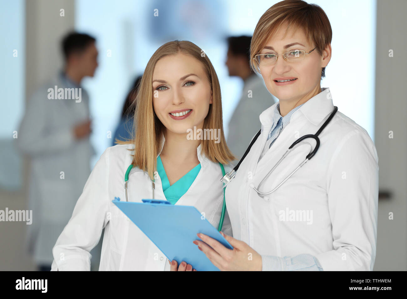 Smiling female doctors standing hi-res stock photography and images - Alamy