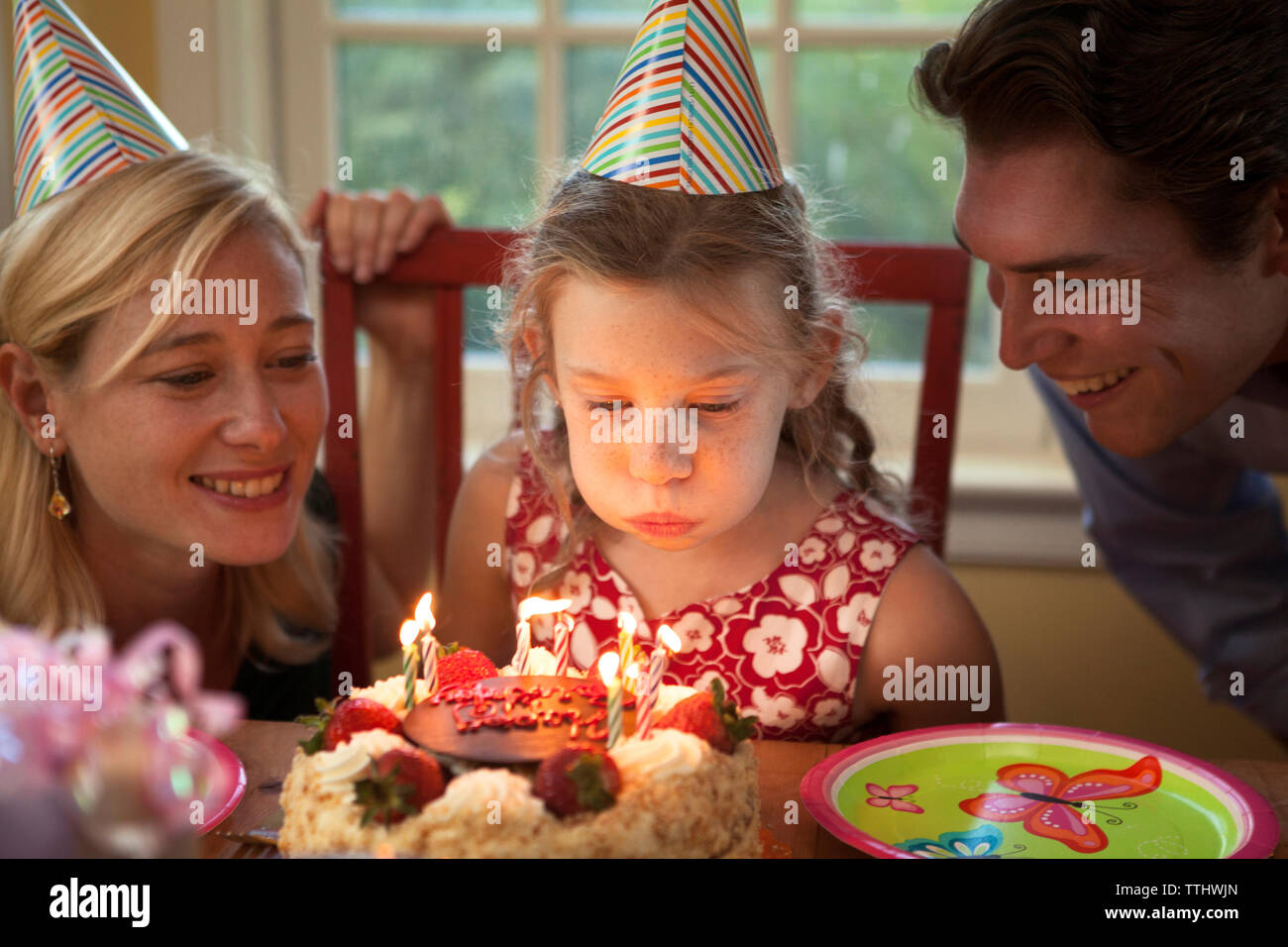 Parents celebrating daughter birthday at home Stock Photo - Alamy