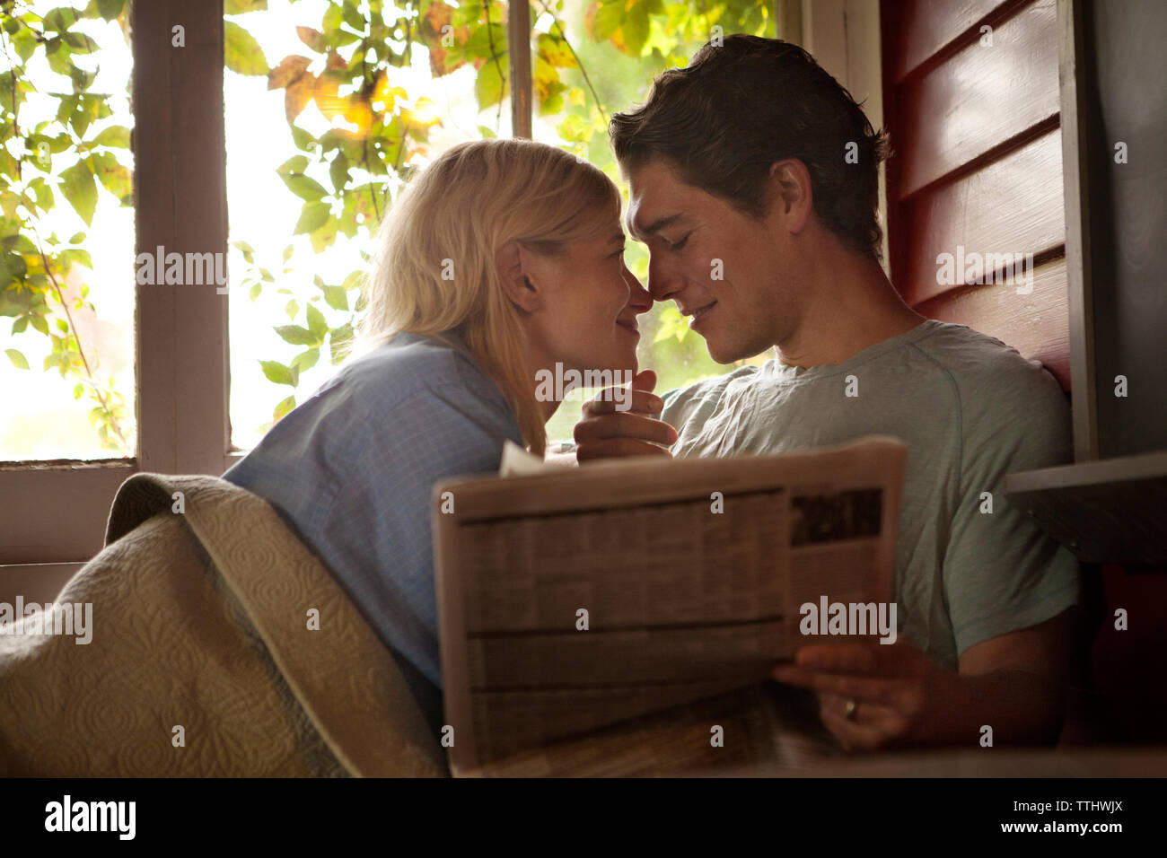 Romantic couple sitting by window at home Stock Photo - Alamy