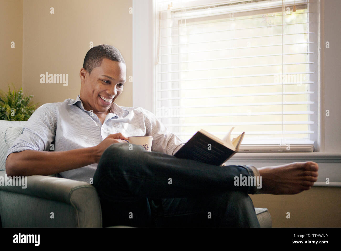 African man sitting reading book hi-res stock photography and images ...