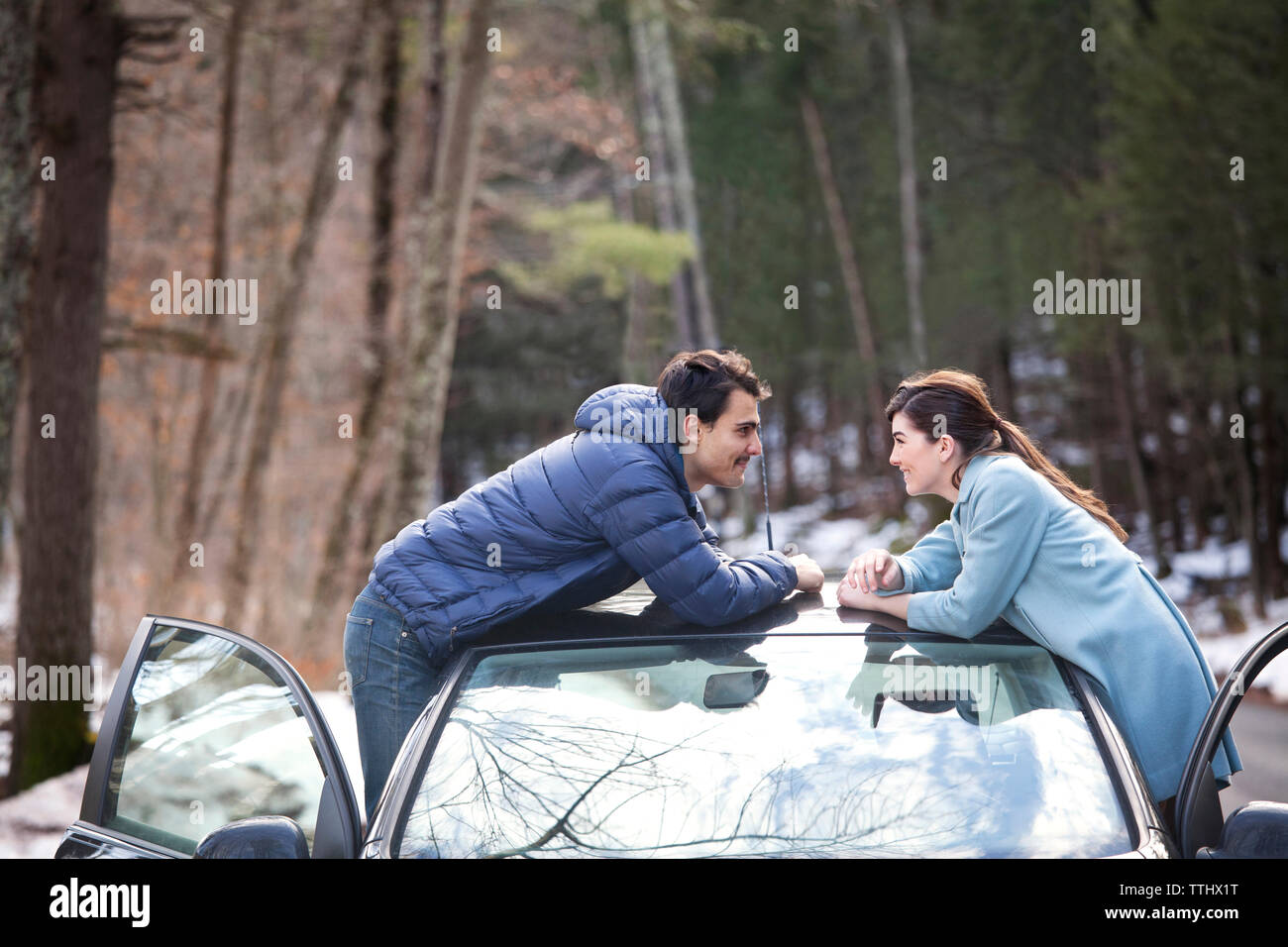 Happy couple leaning on car Stock Photo - Alamy