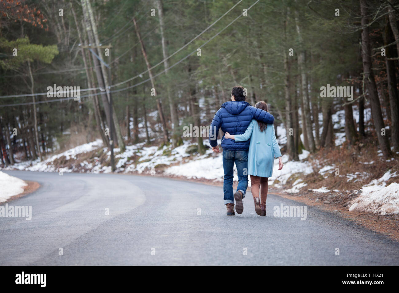 Rear view of couple walking on road Stock Photo - Alamy