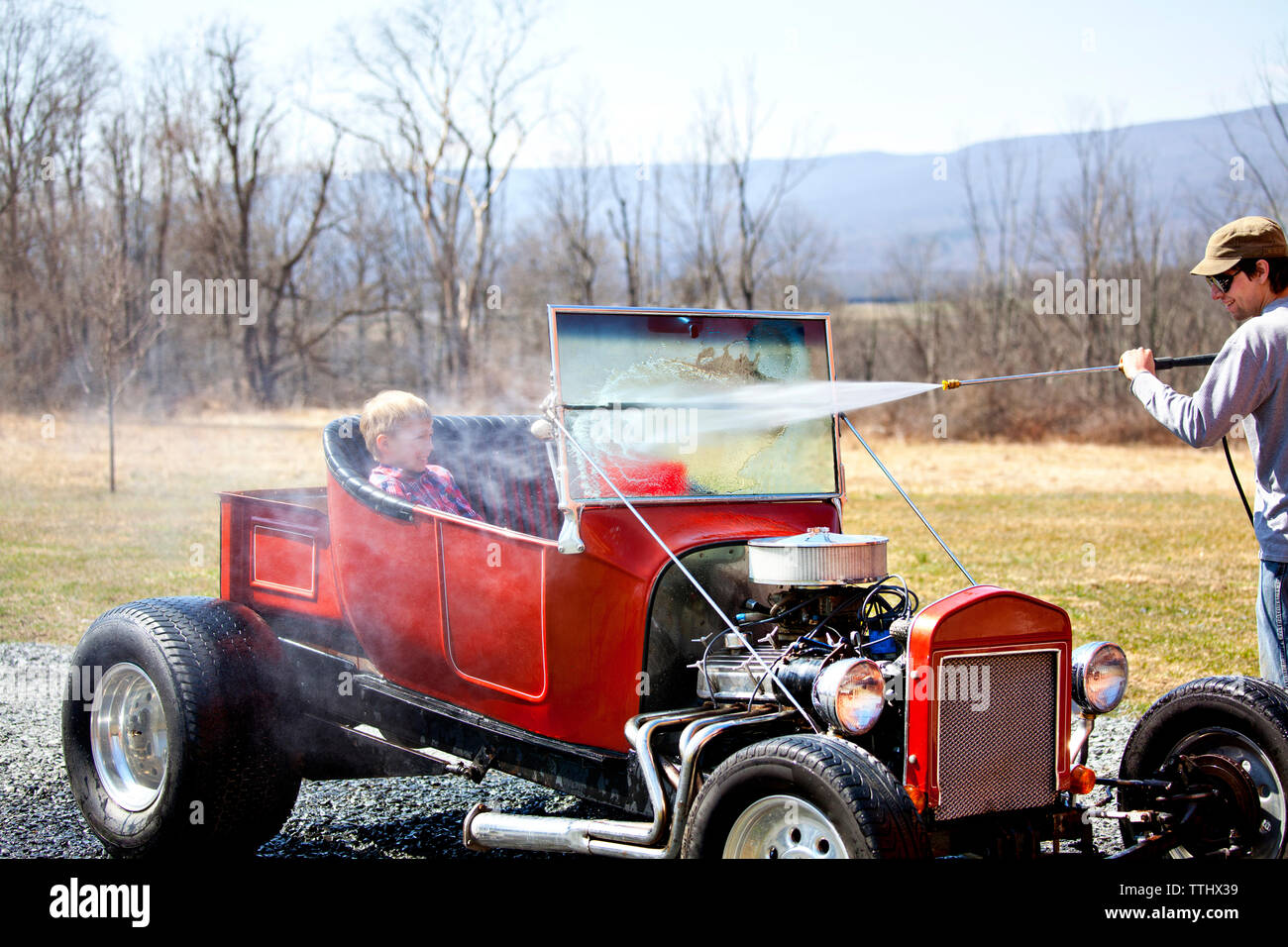 Young man washing vintage car while boy sitting in it Stock Photo - Alamy