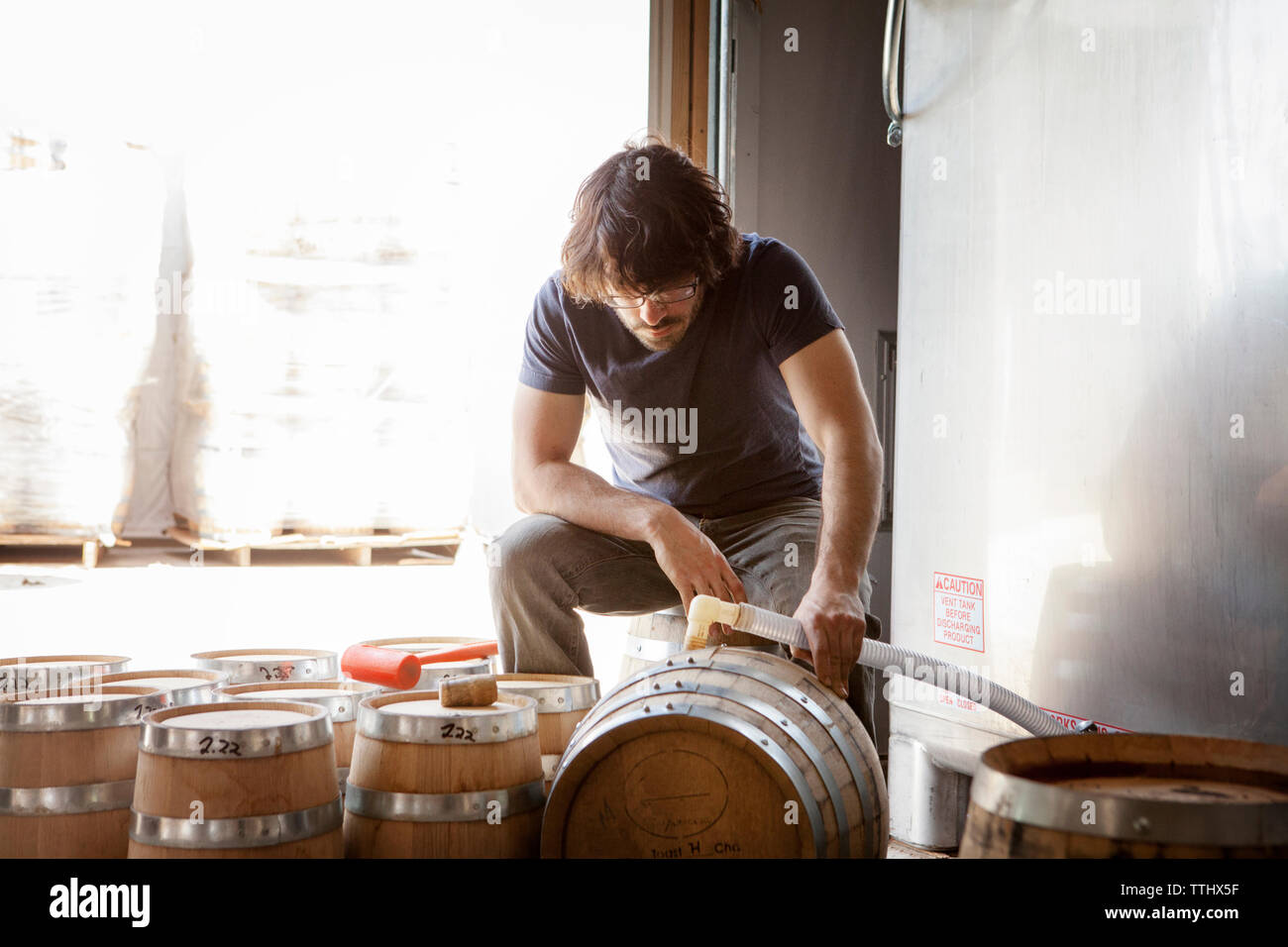 Man filling whiskey in barrel at distillery Stock Photo - Alamy