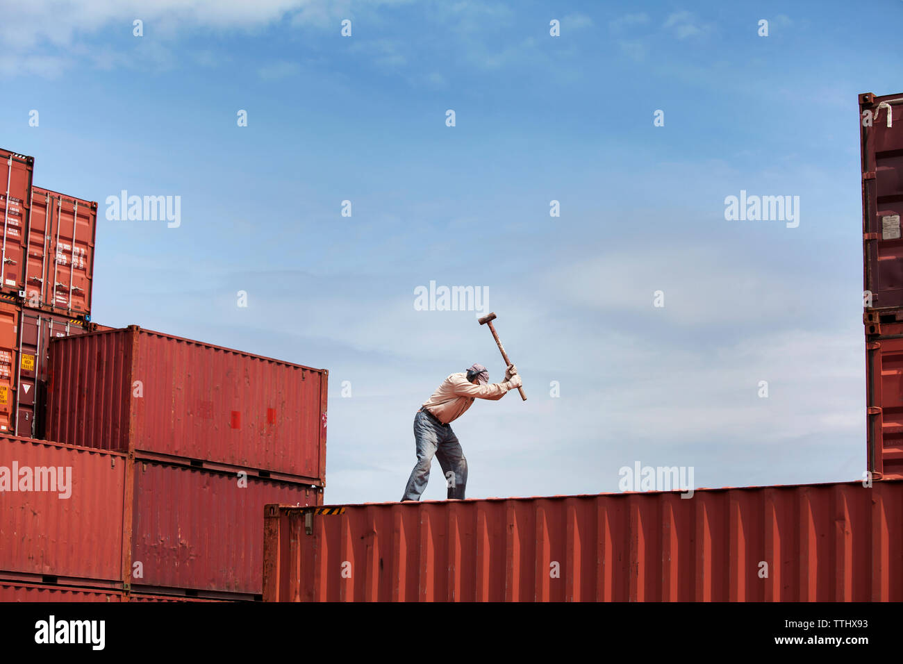 Worker working on cargo container at commercial dock Stock Photo - Alamy