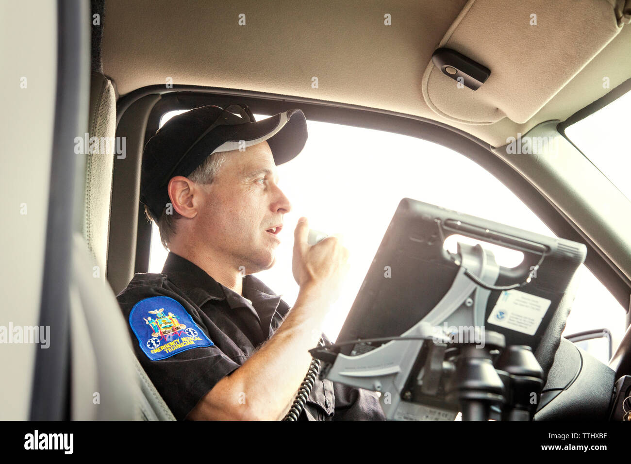 Paramedic using CB radio while sitting in ambulance Stock Photo - Alamy