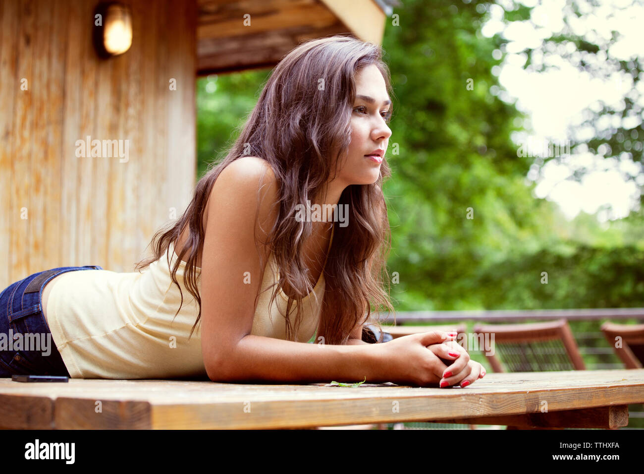 Thoughtful woman leaning on table at tourist resort Stock Photo - Alamy