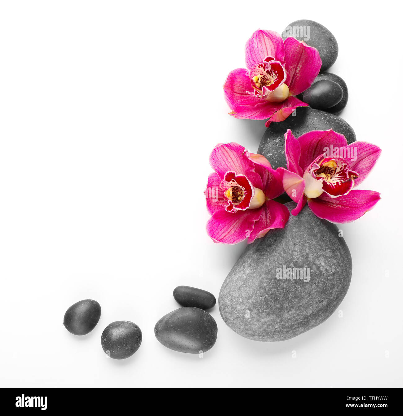 Spa stones and red orchid isolated on white Stock Photo - Alamy