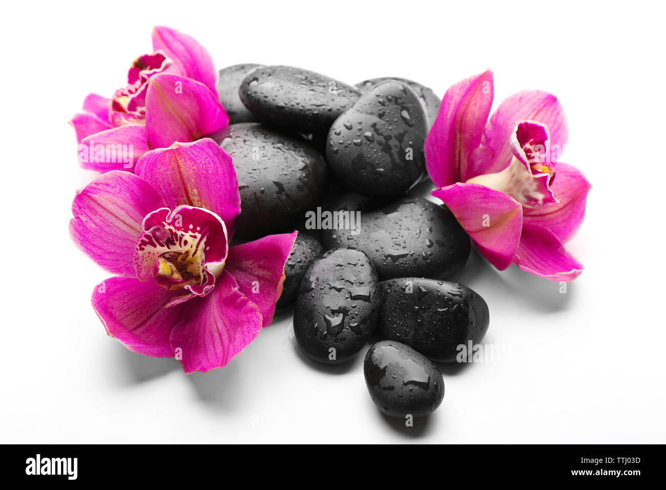 Spa stones and red orchid isolated on white Stock Photo - Alamy