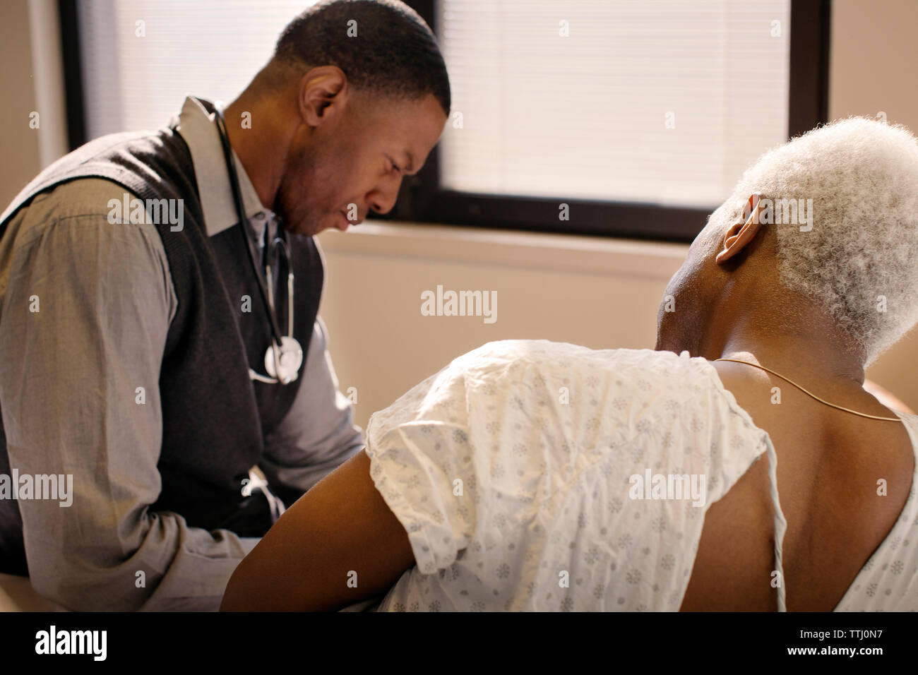 Rear view of patient with doctor in hospital Stock Photo - Alamy