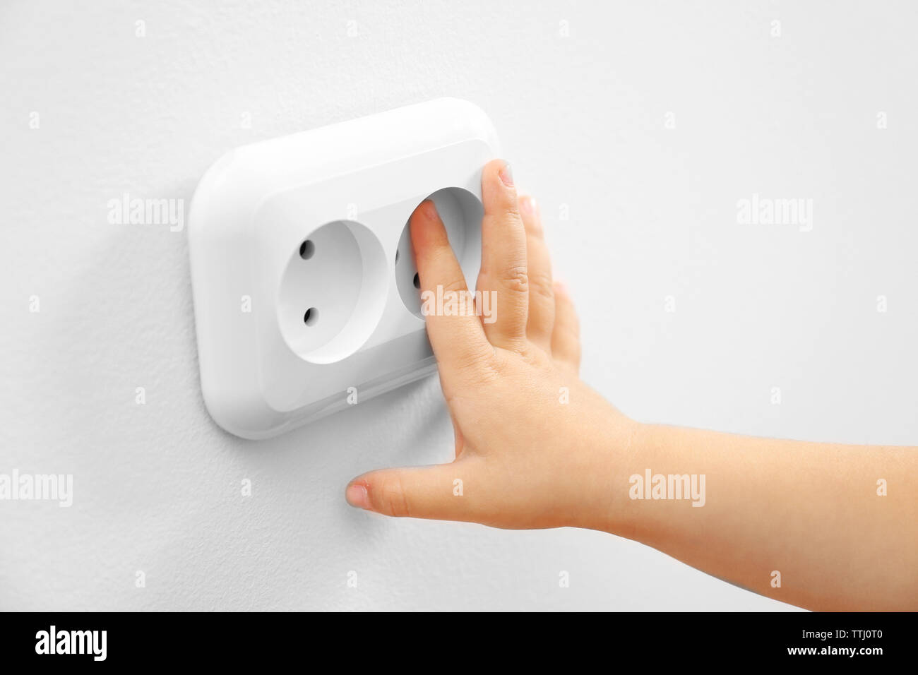 Little child putting finger in power socket, closeup Stock Photo - Alamy