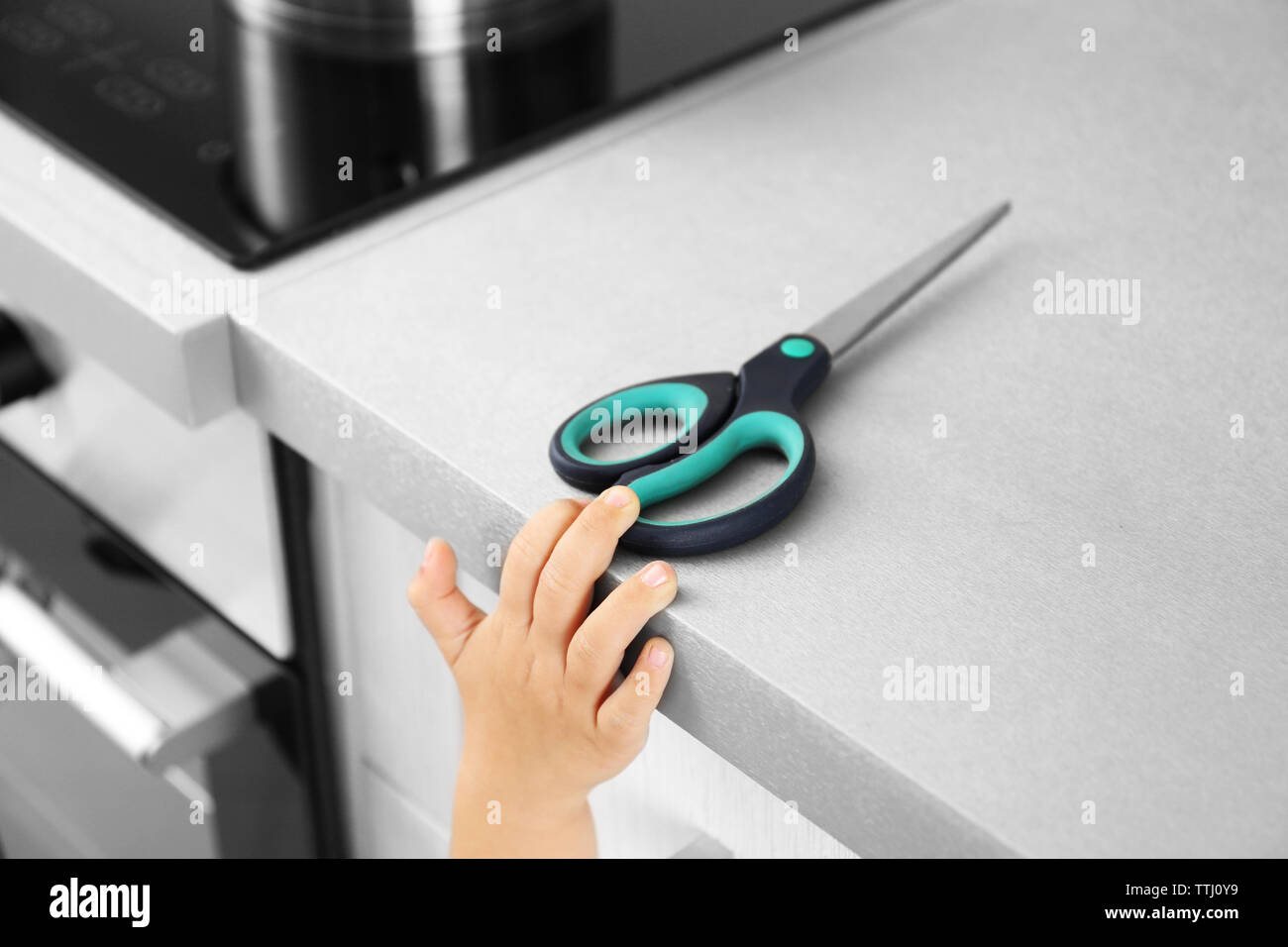 Little girl playing with scissors in kitchen Stock Photo - Alamy