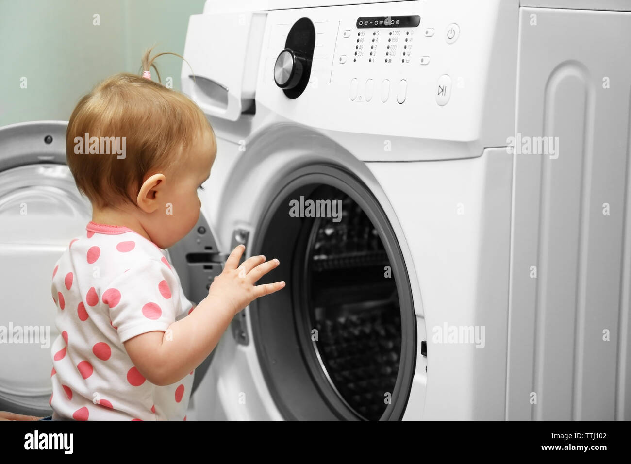 Little girl and washing machine in bathroom Stock Photo - Alamy