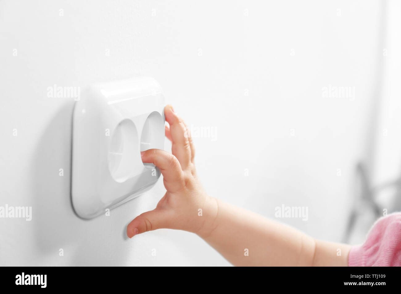 Little child's hand playing with power socket, closeup Stock Photo - Alamy