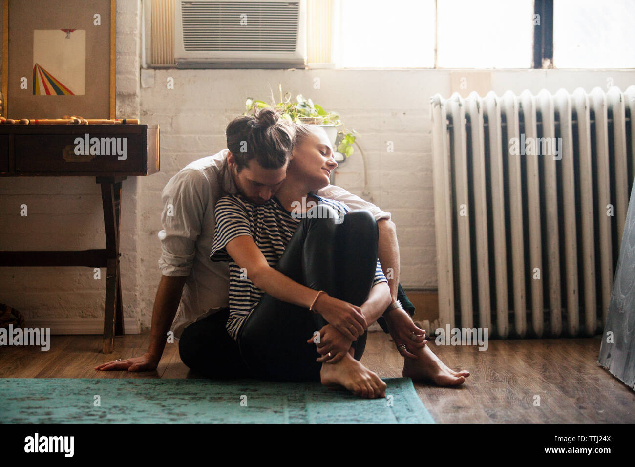 Romantic couple sitting on floor at home Stock Photo - Alamy