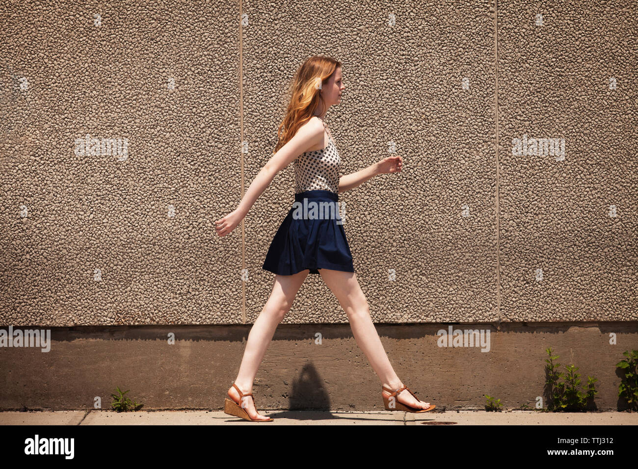 Side view of woman walking on footpath Stock Photo - Alamy