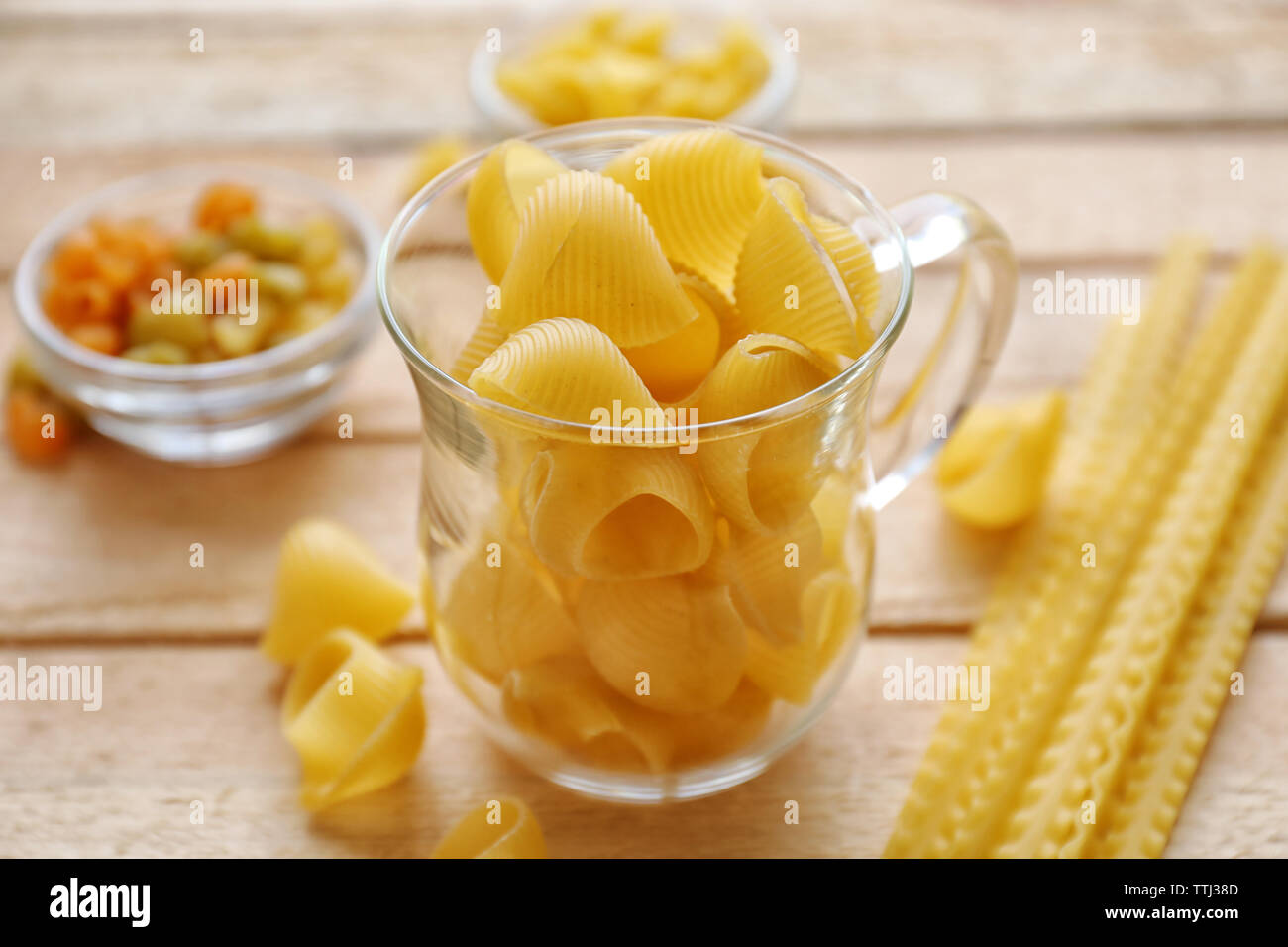 Pipe rigate pasta in cup on wooden table background Stock Photo - Alamy