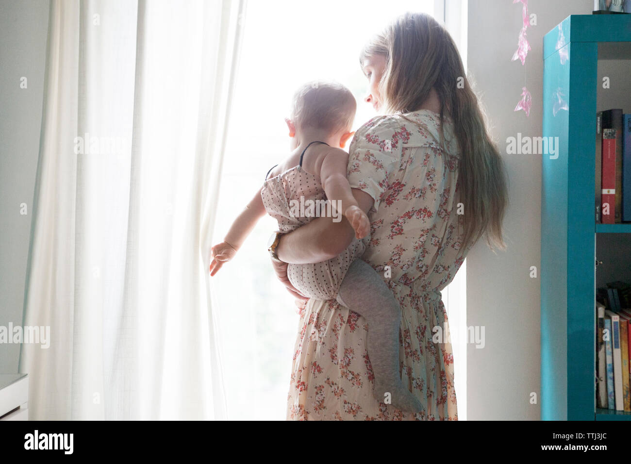 Woman looking through bookshelf hi-res stock photography and images - Alamy
