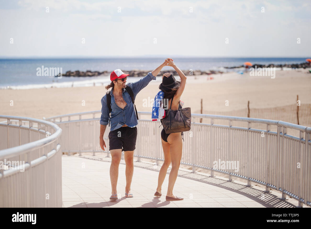 Happy couple dancing on boardwalk at beach during summer vacation Stock ...