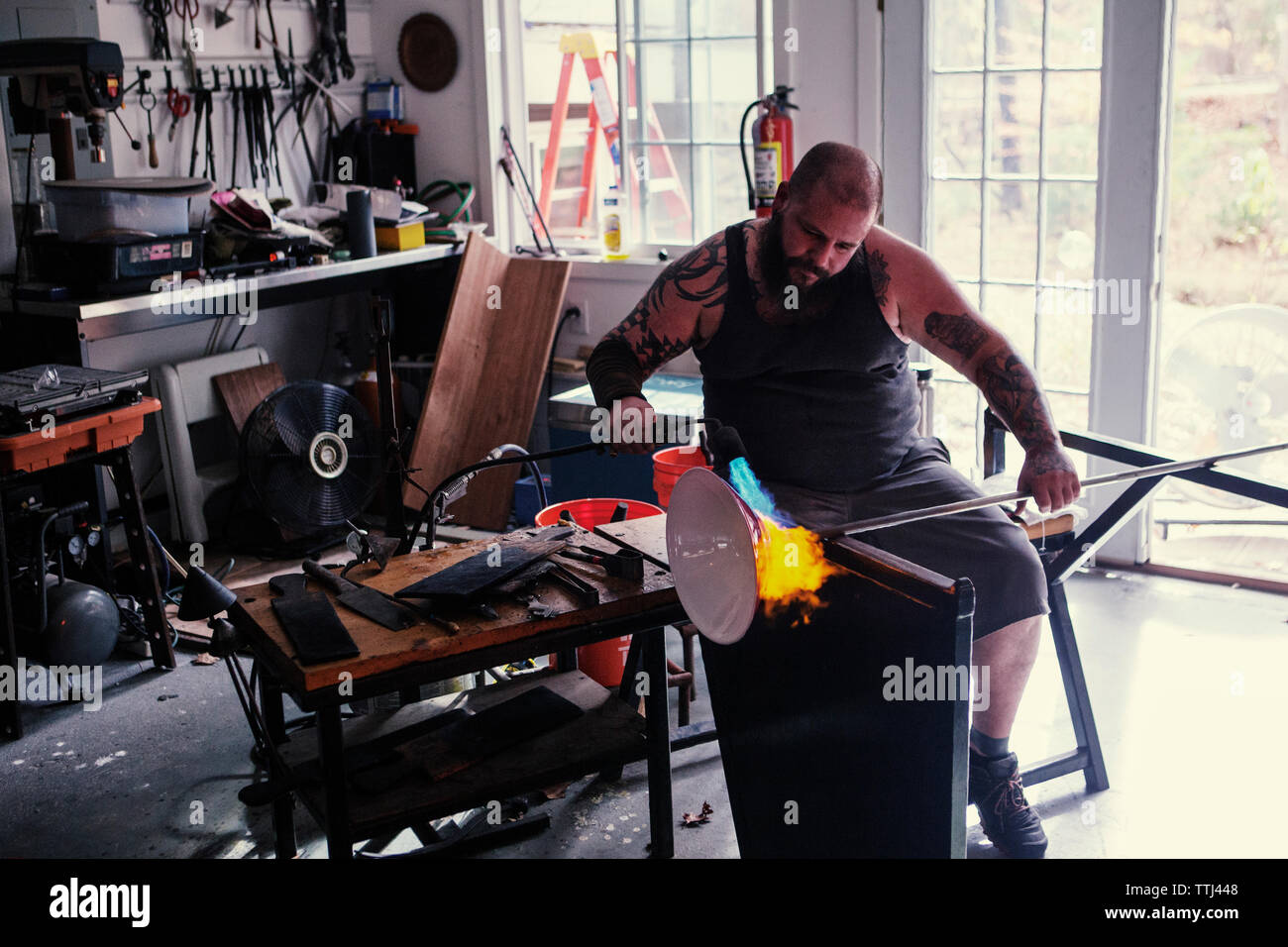 Glass blower molding shape with blowpipe in workshop Stock Photo - Alamy