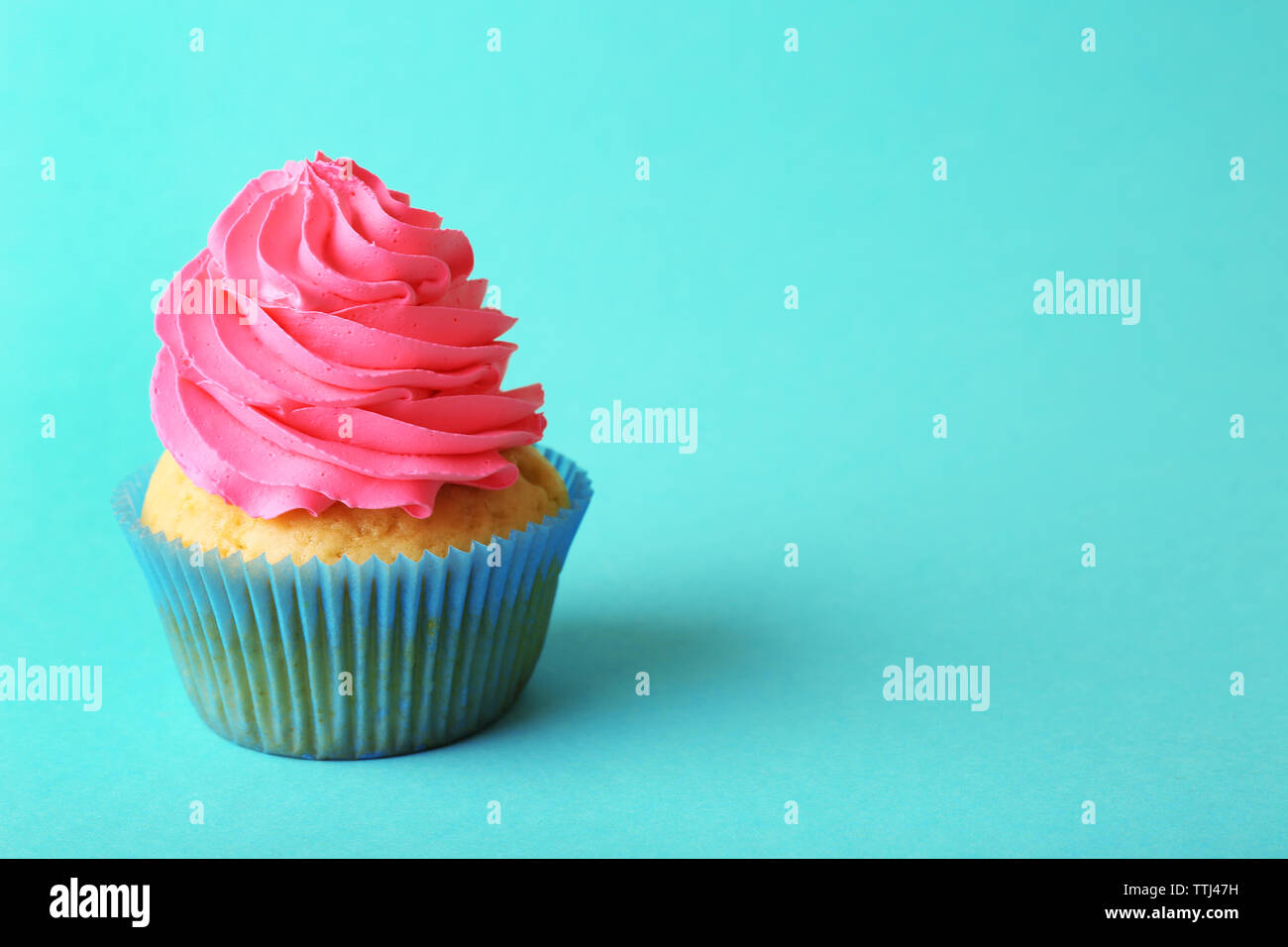 Birthday cupcake on turquoise background Stock Photo - Alamy