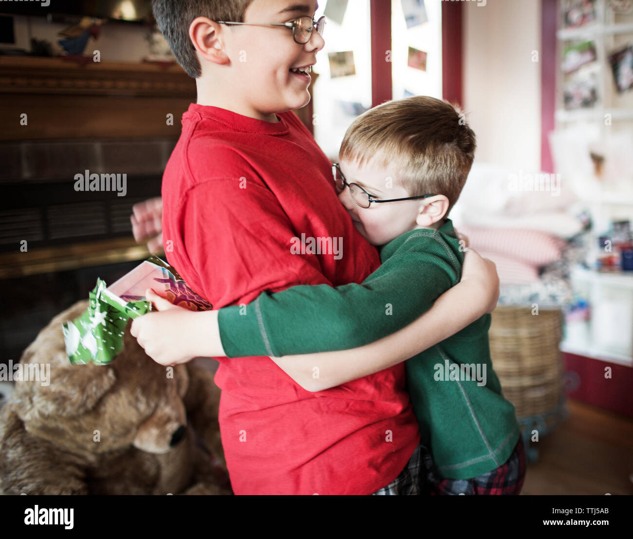 Side view of brothers embracing at home Stock Photo - Alamy