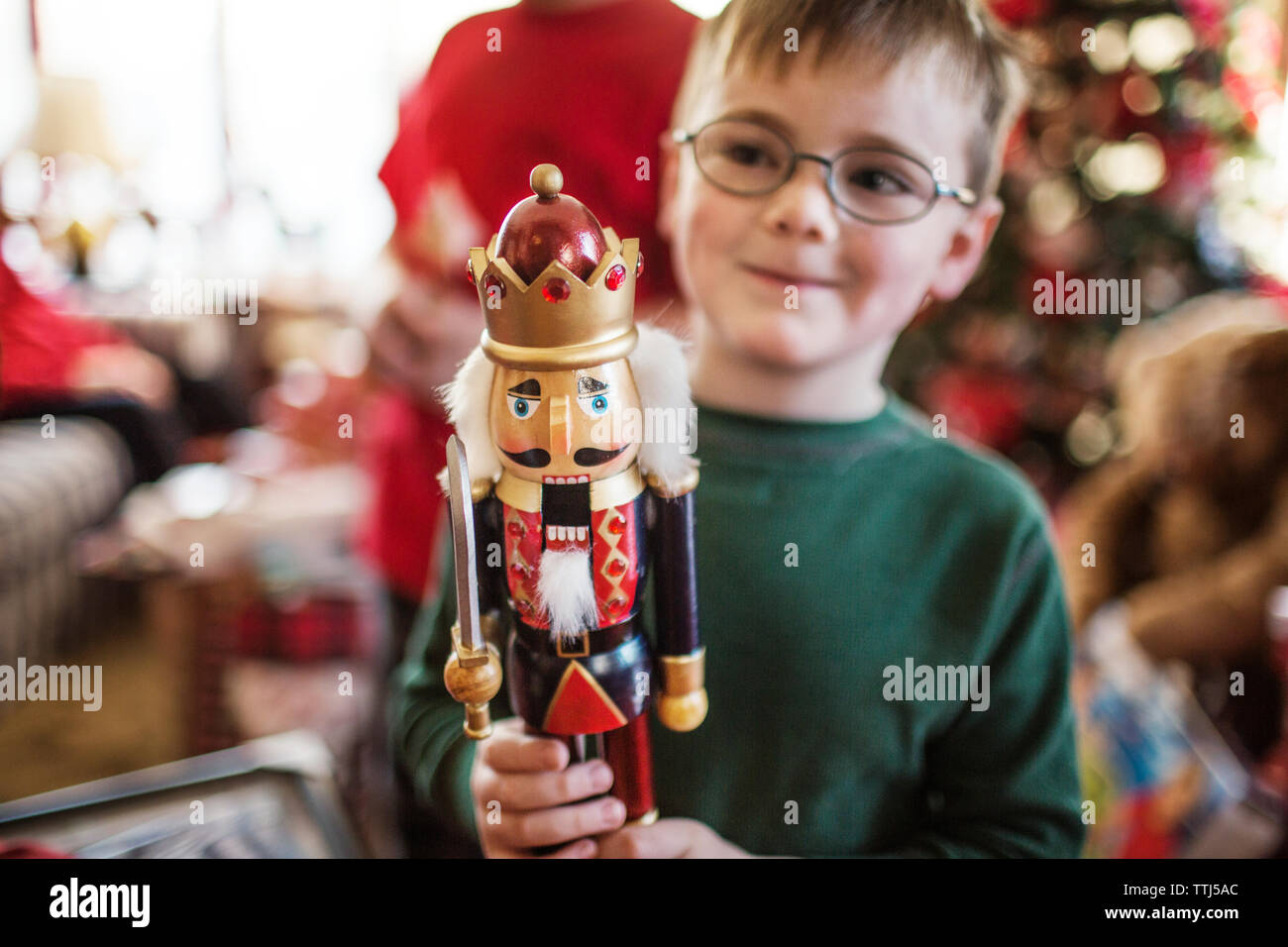 Boy holding toy soldier standing by brother at home Stock Photo - Alamy