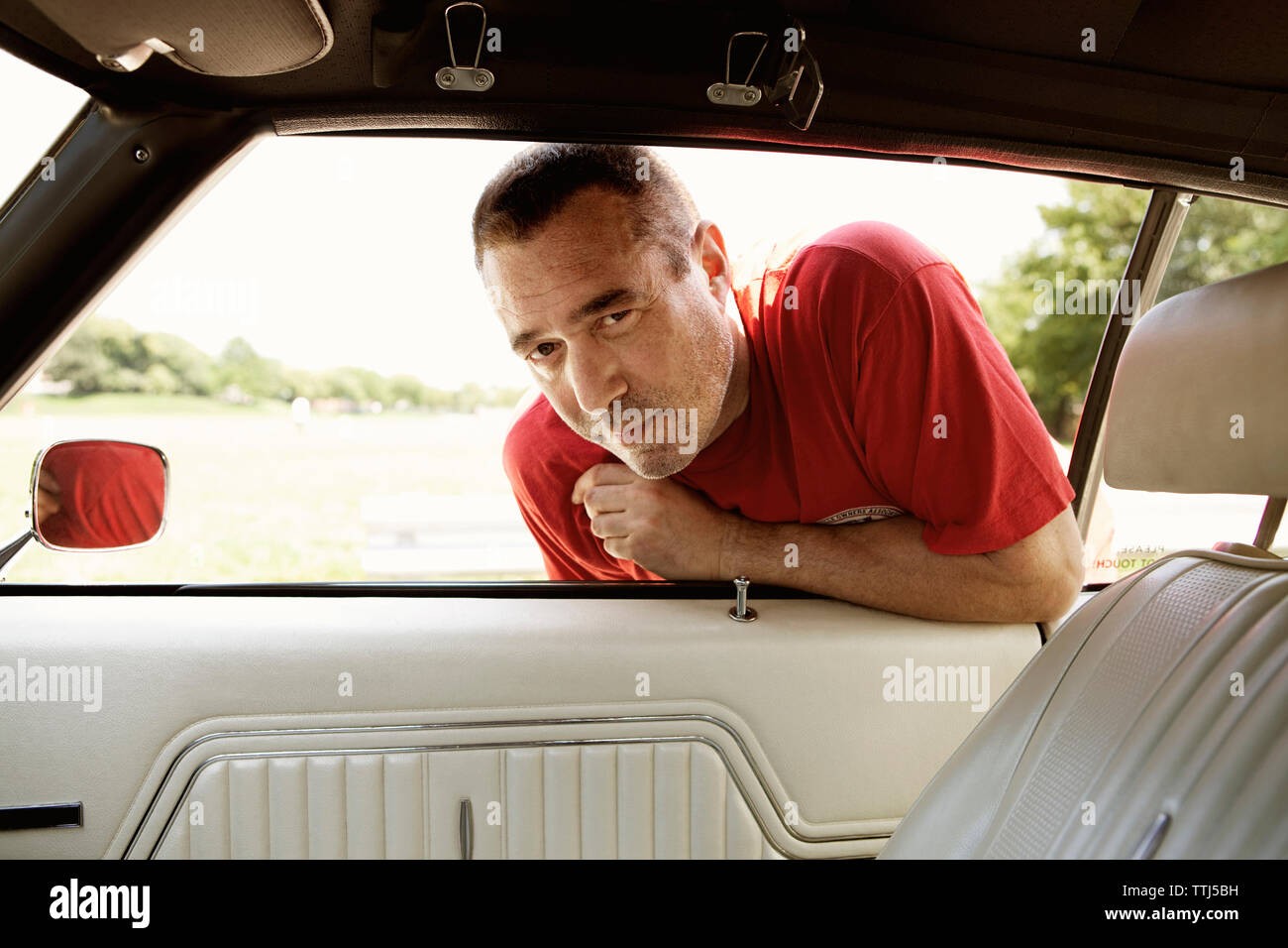 Portrait of man leaning on car window Stock Photo - Alamy