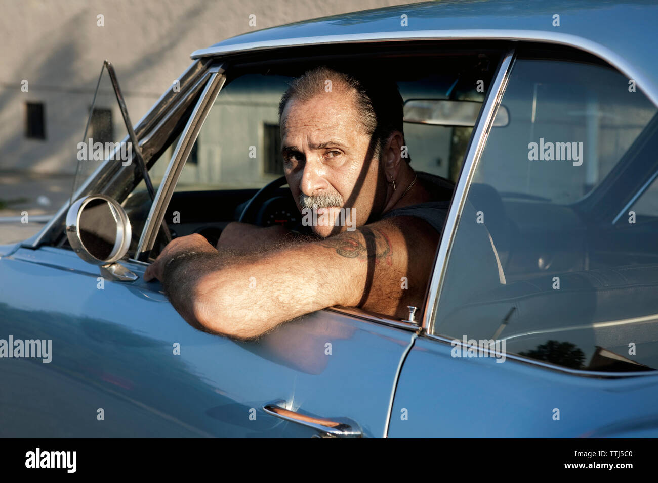 Portrait of man looking through car window Stock Photo - Alamy