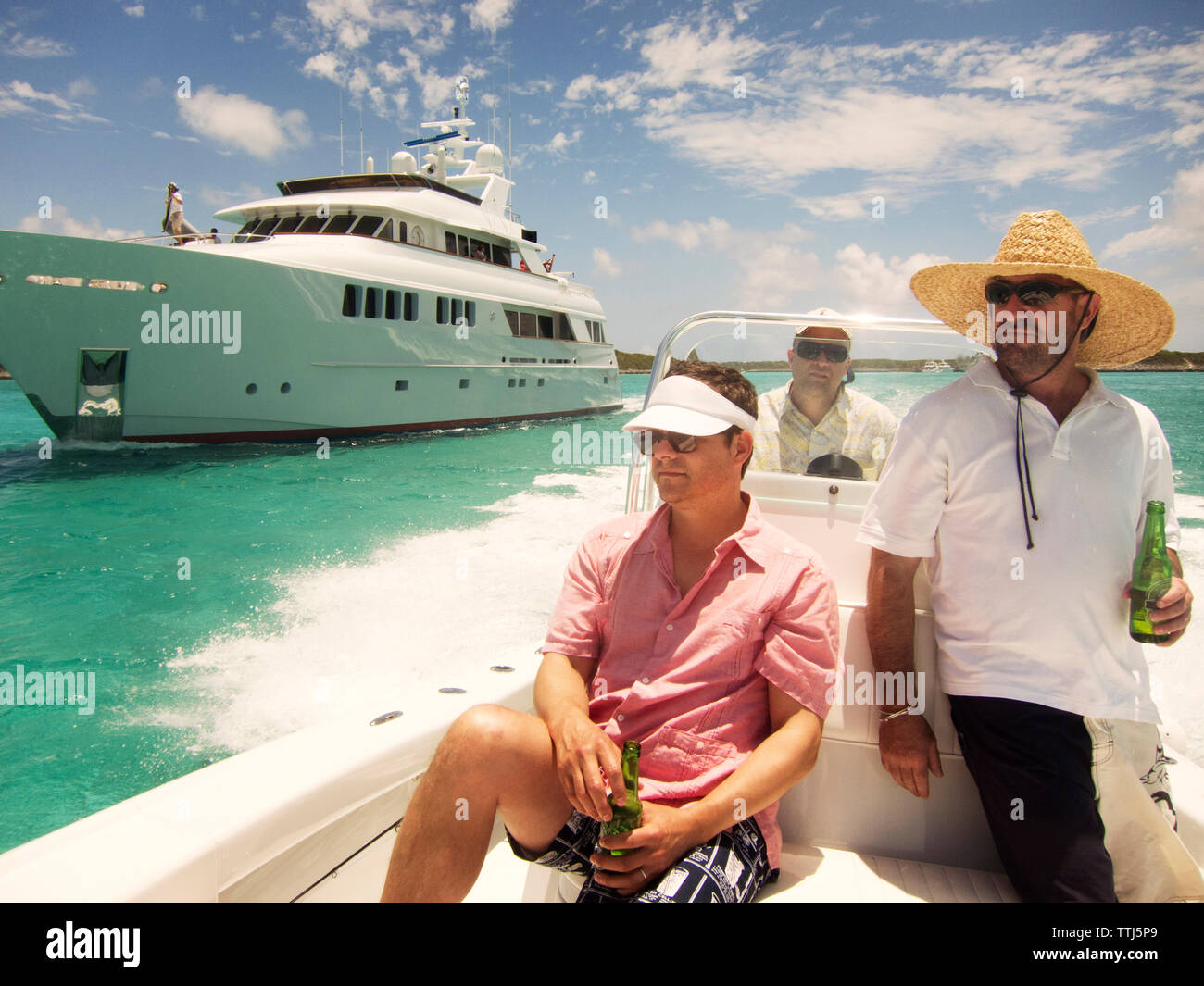 Friends sitting in motorboat at sea Stock Photo - Alamy