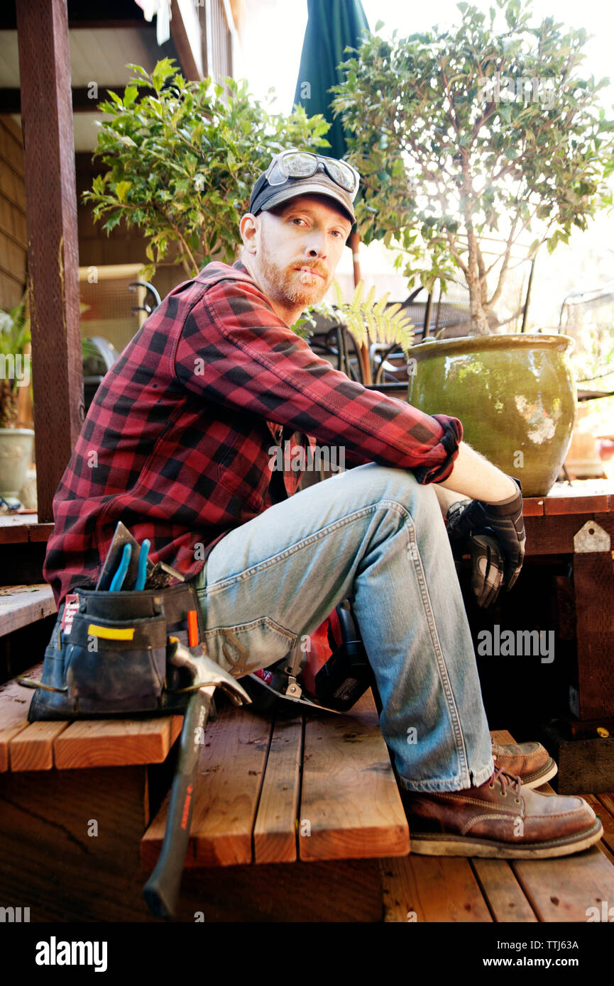 Portrait of confident carpenter sitting on steps Stock Photo - Alamy