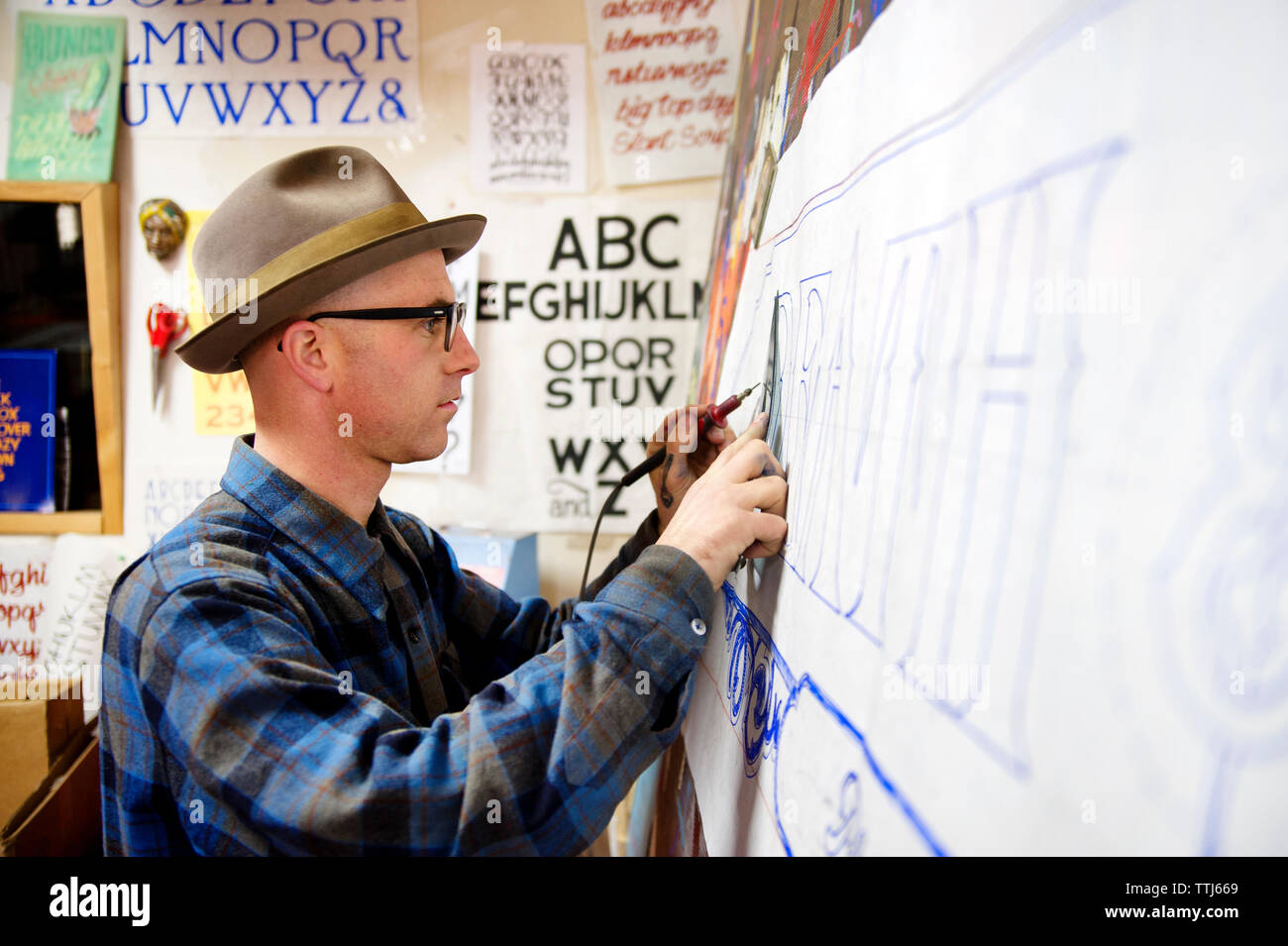 Man writing on paper in workshop Stock Photo - Alamy