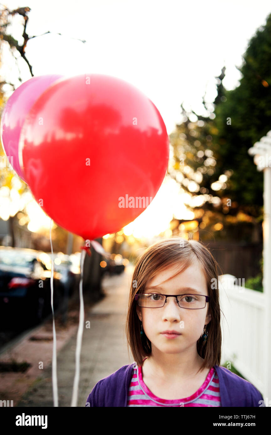 Portrait of girl holding balloons Stock Photo - Alamy