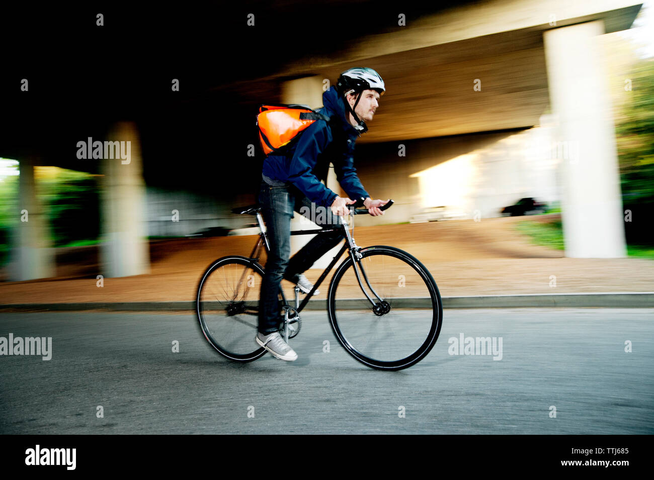 Side view of cyclist riding bicycle Stock Photo - Alamy