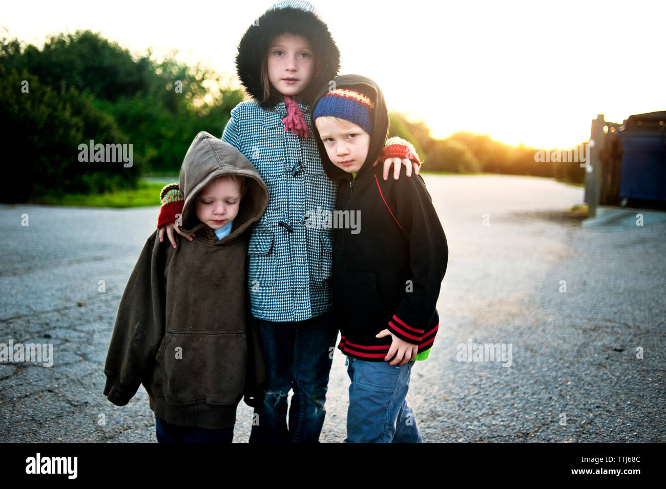 Portrait of siblings standing on road Stock Photo - Alamy