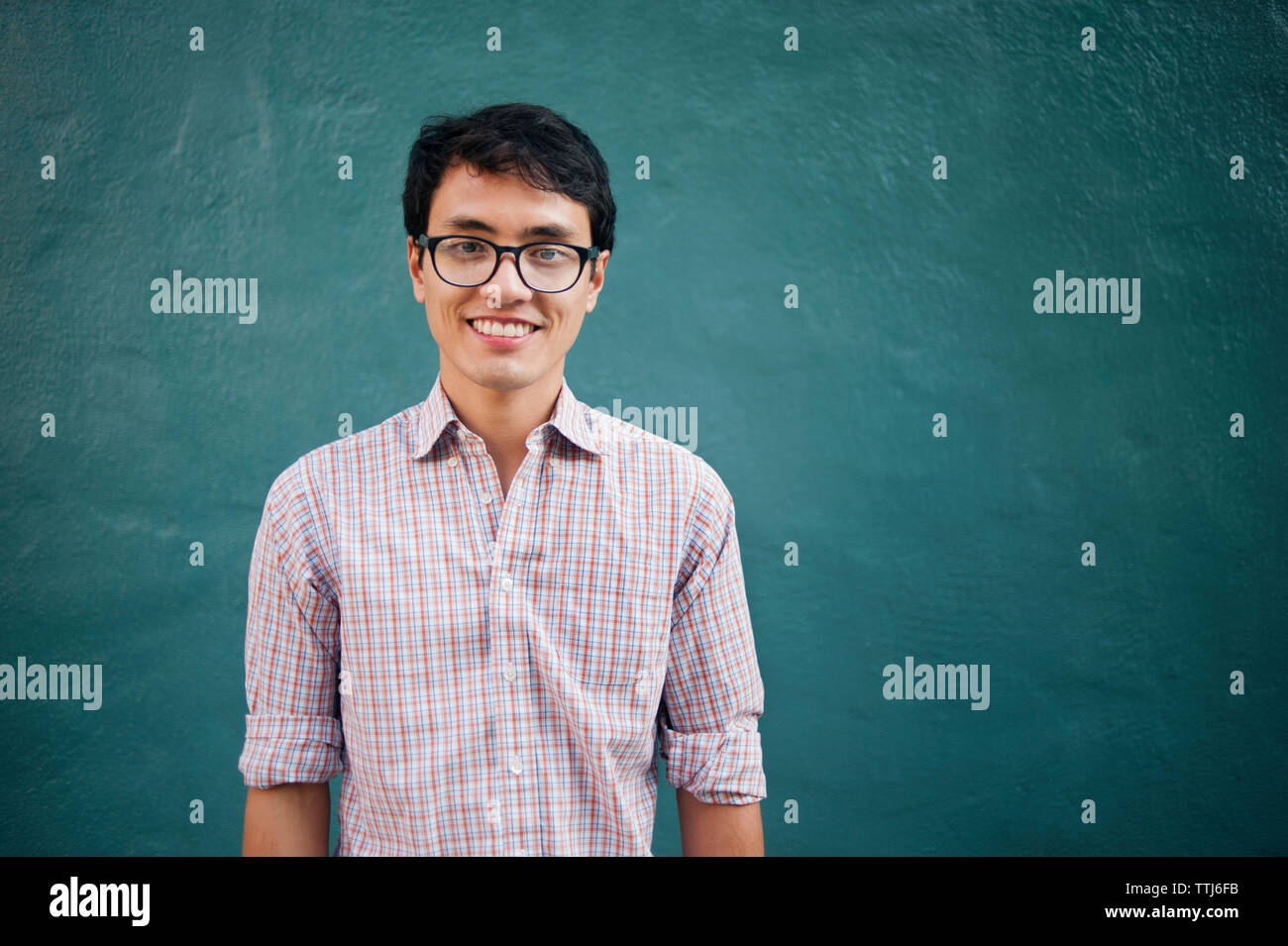 Portrait of man standing against wall Stock Photo - Alamy