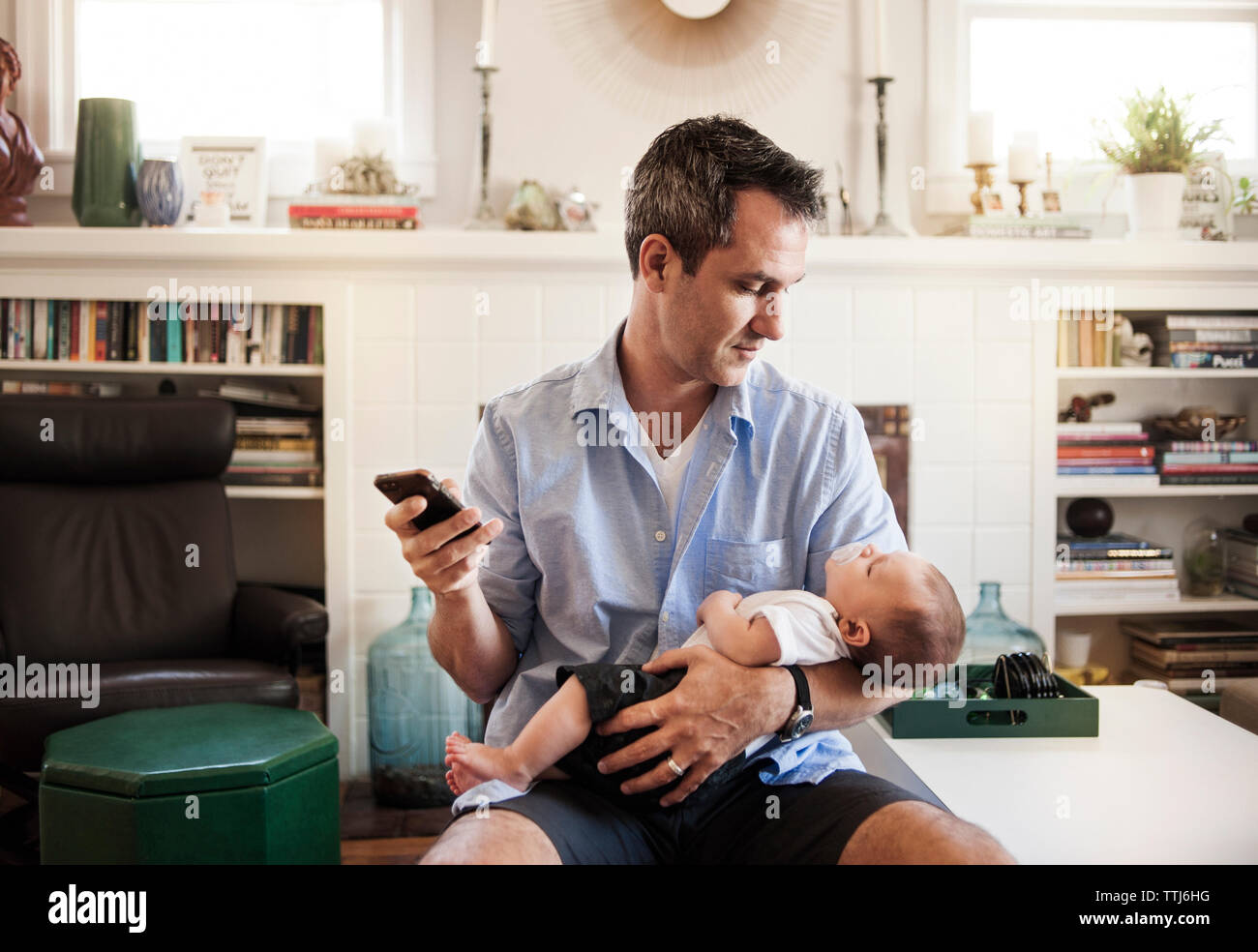 Man looking phone family hi-res stock photography and images - Alamy