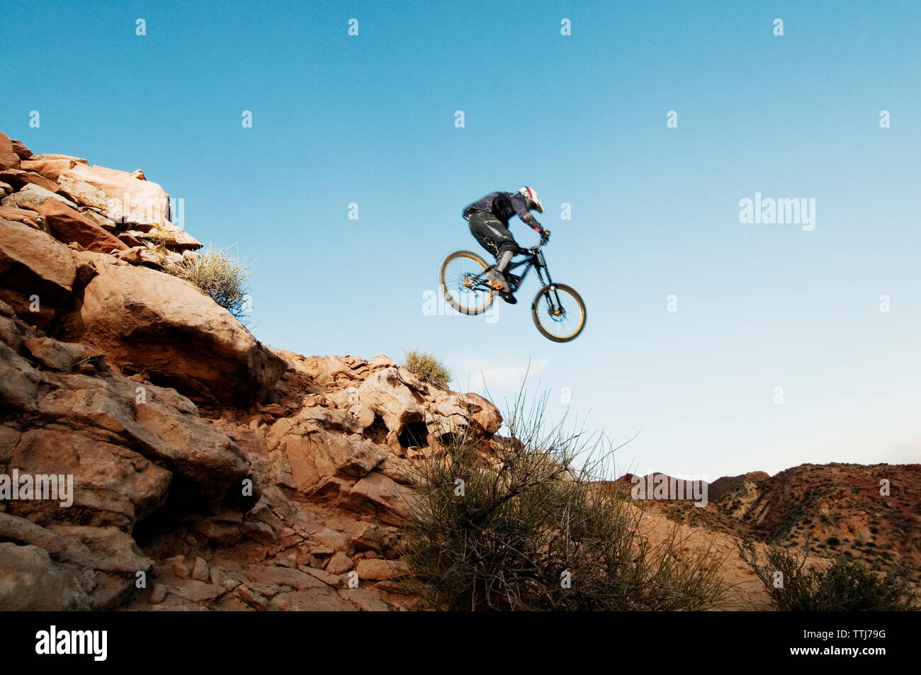 Low angle view of mountain biker performing stunt in mid-air Stock ...