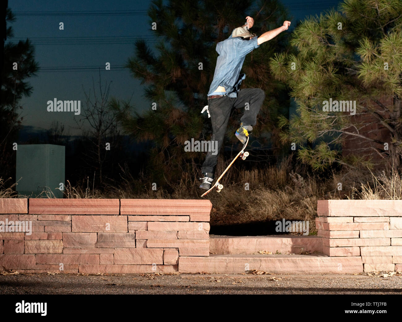 Side view of man jumping with skateboard at night Stock Photo - Alamy