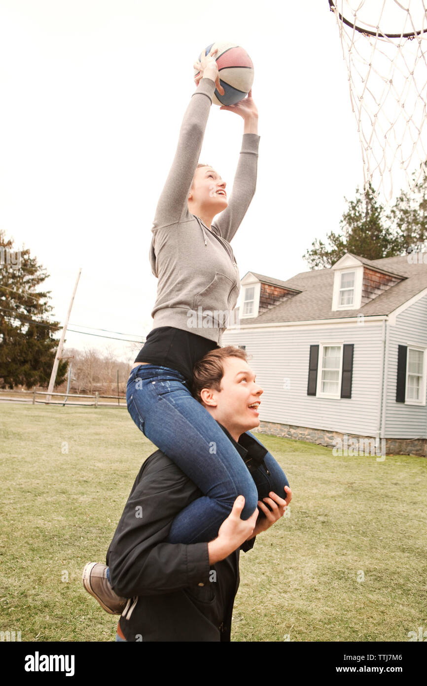Man carrying woman while playing basket ball Stock Photo - Alamy