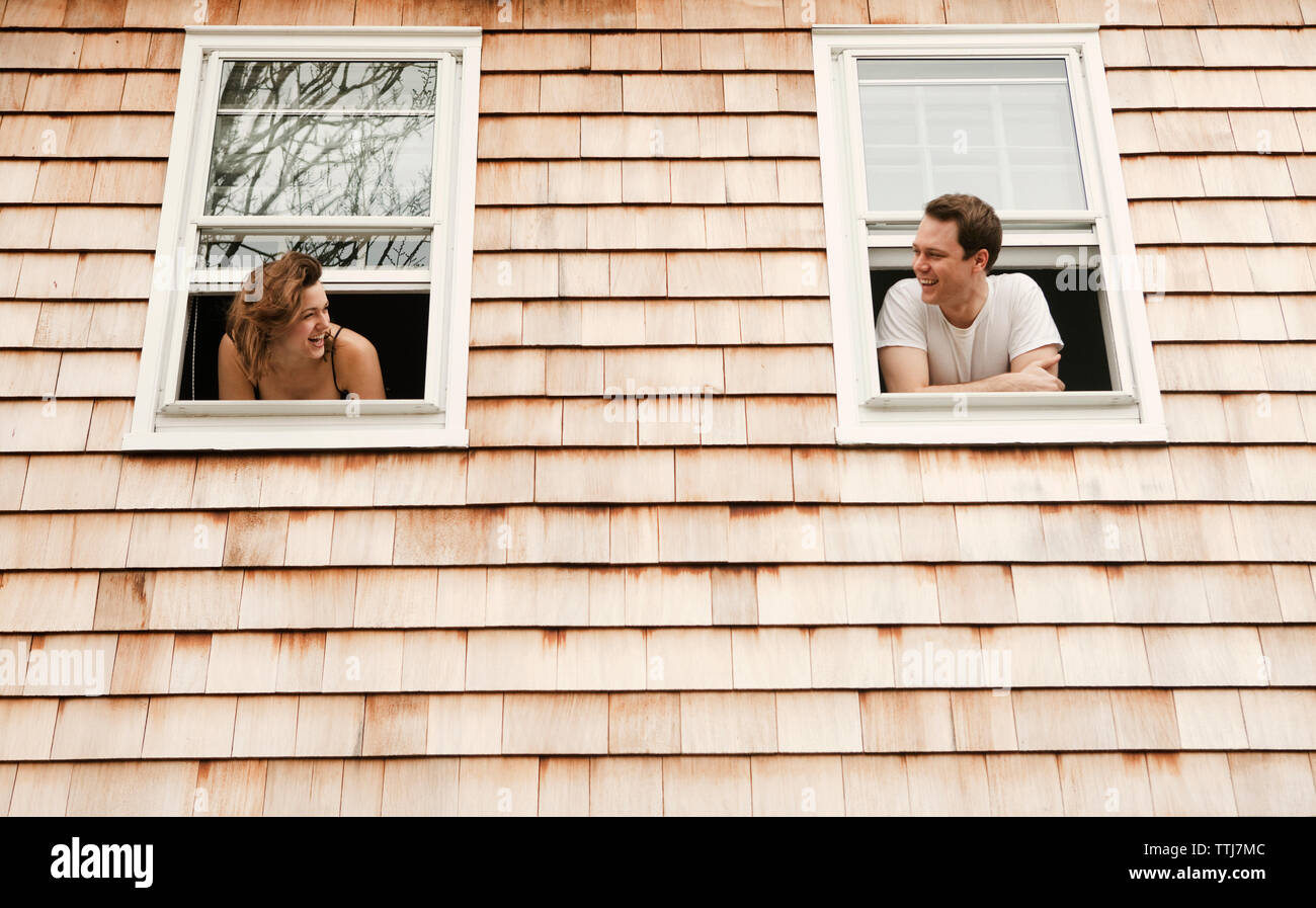 Couple leaning on windows at home Stock Photo - Alamy