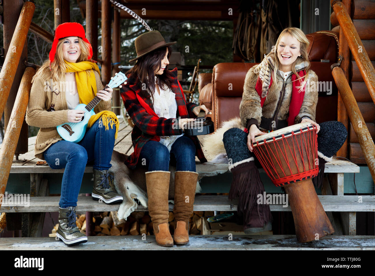 Cheerful siblings playing musical instruments while sitting on stairs ...