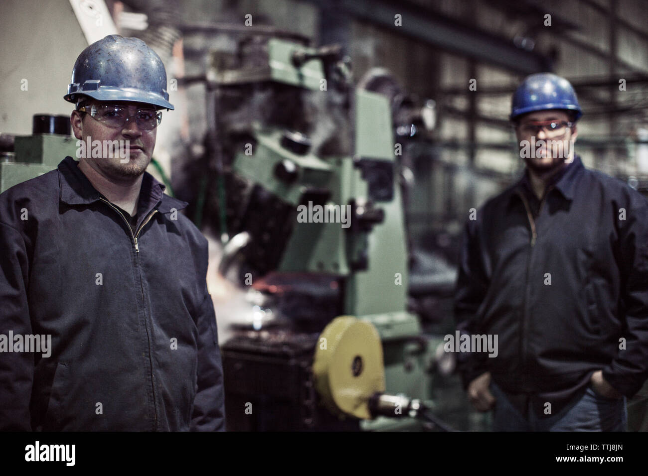 Portrait of coworkers standing in factory Stock Photo - Alamy